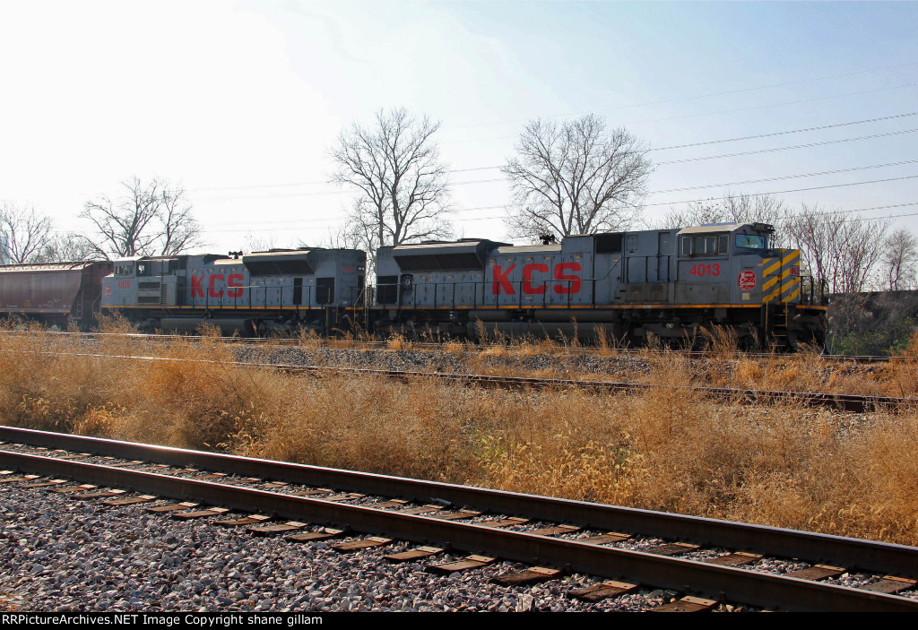 KCS 4013 sits on a tied down grain train.